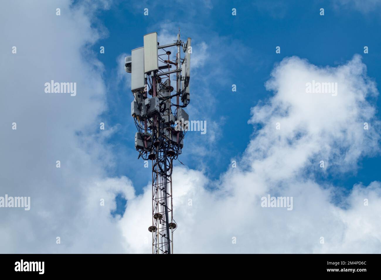 Mobile telecommunication tower in clouds, cell tower with antennas and electronic communications ...