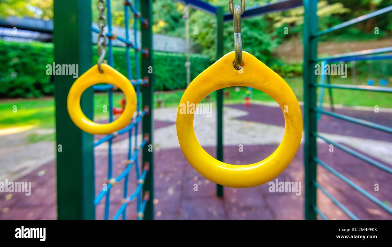 Yellow Metal Trapeze Rings for Swing Sets in the garden Stock Photo - Alamy