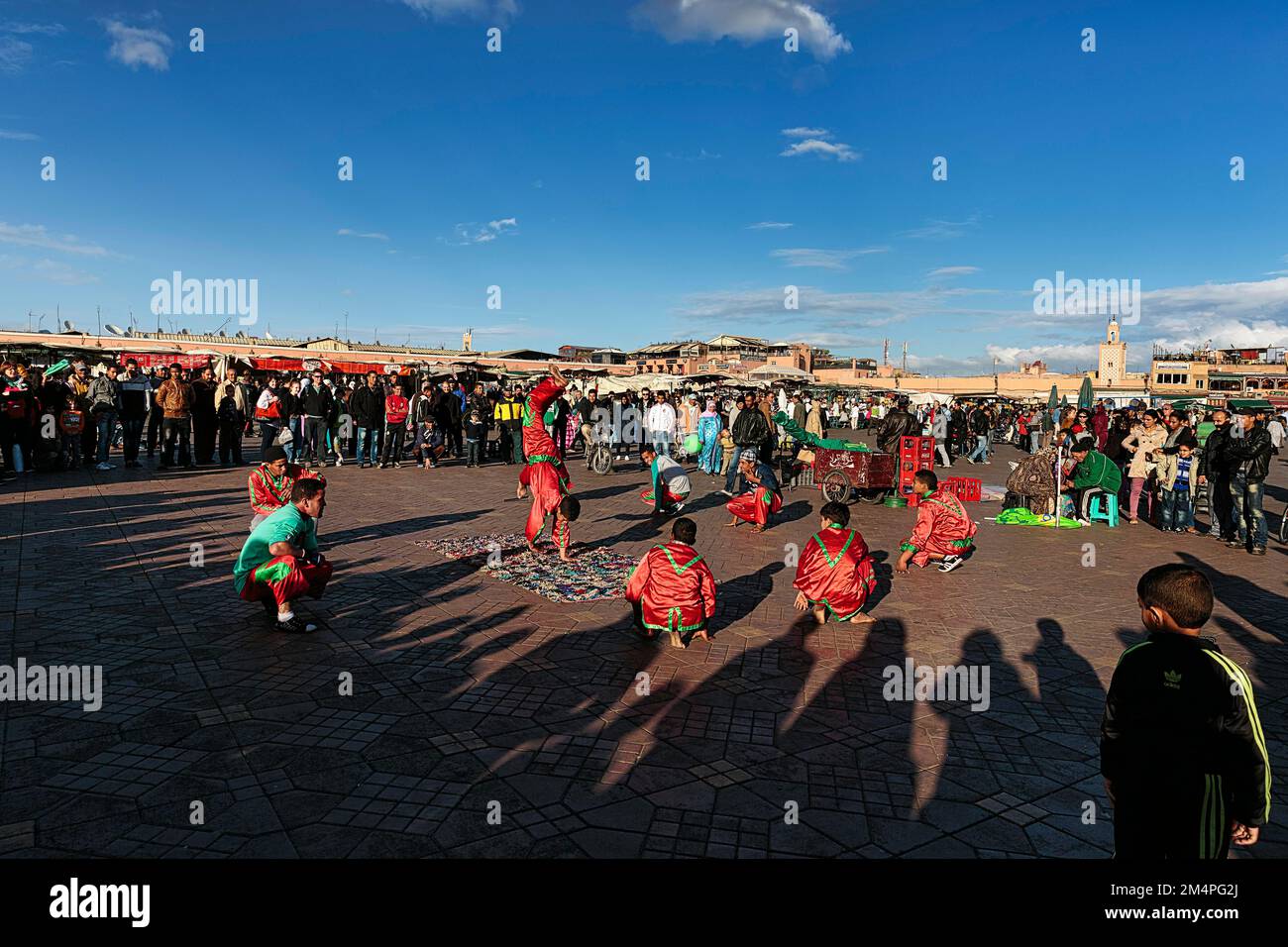 Acrobats in traditional dress in the bustling marketplace Djemaa el Fna ...