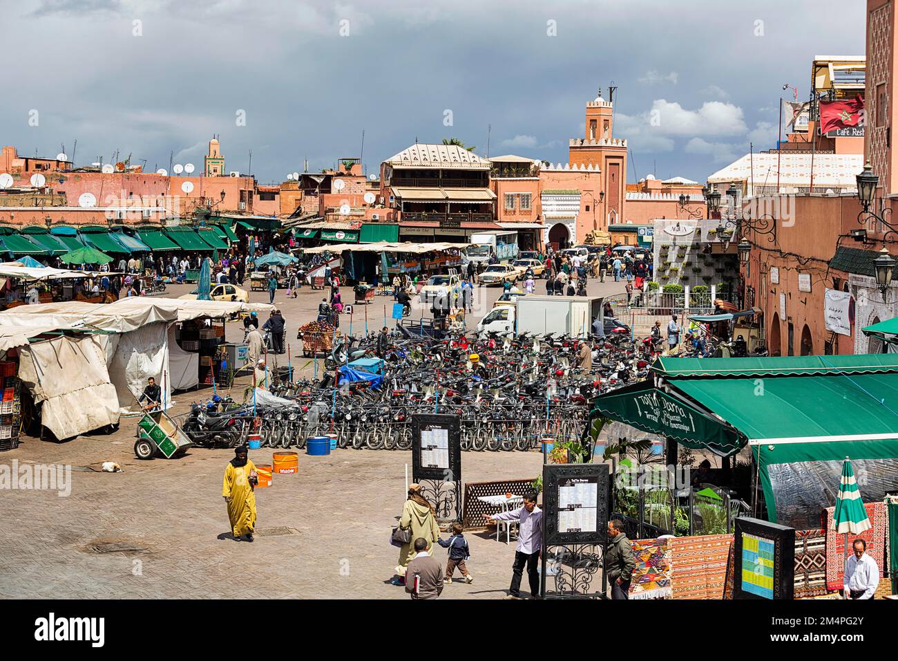 Parking for two-wheelers, market stalls, passers-by, restaurants on the ...