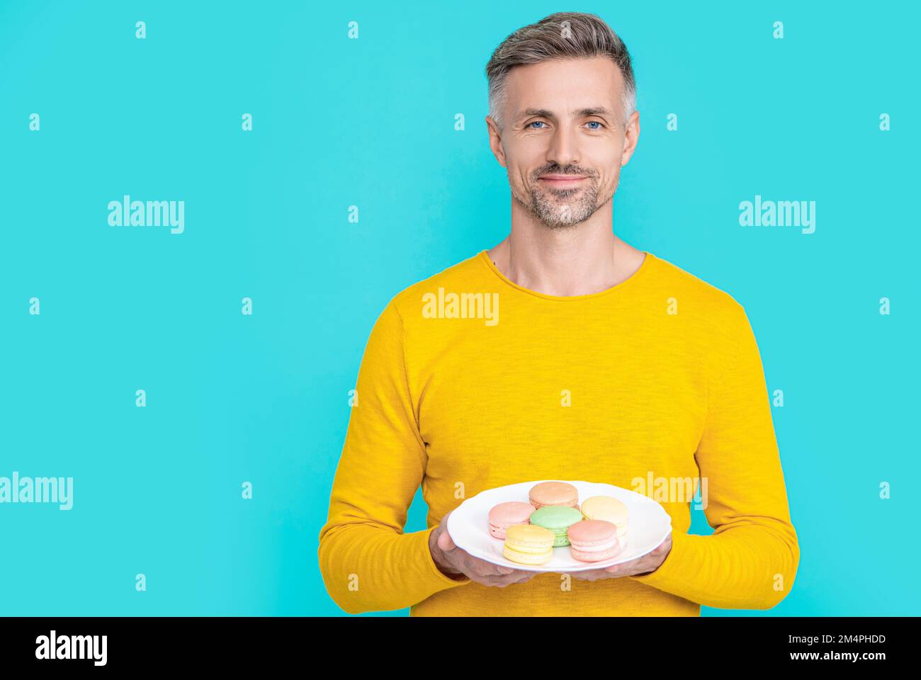 man hold yummy macaroon isolated on blue, copy space. man hold yummy ...