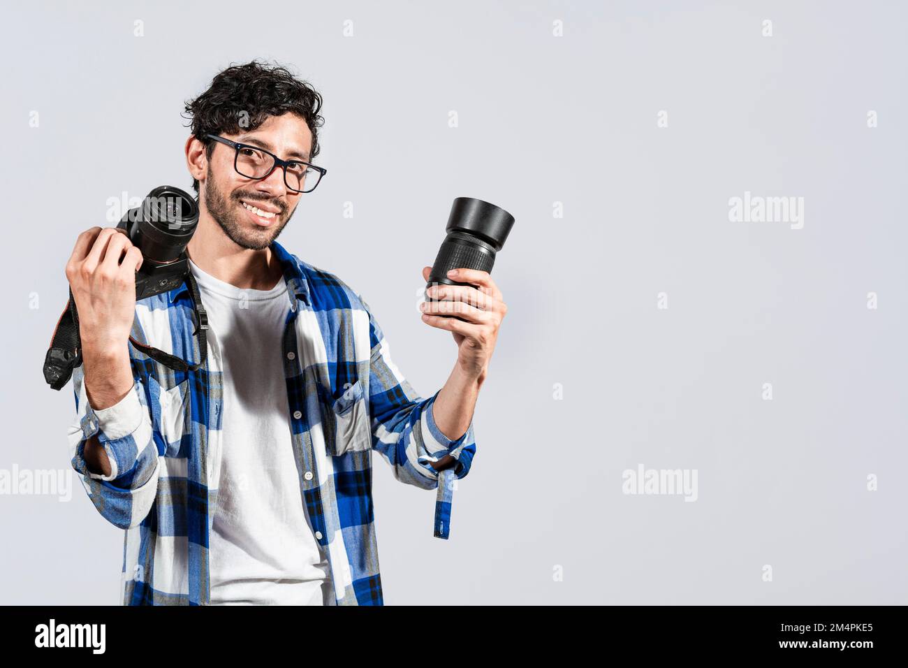 Portrait of smiling photographer man showing a camera and lens on ...