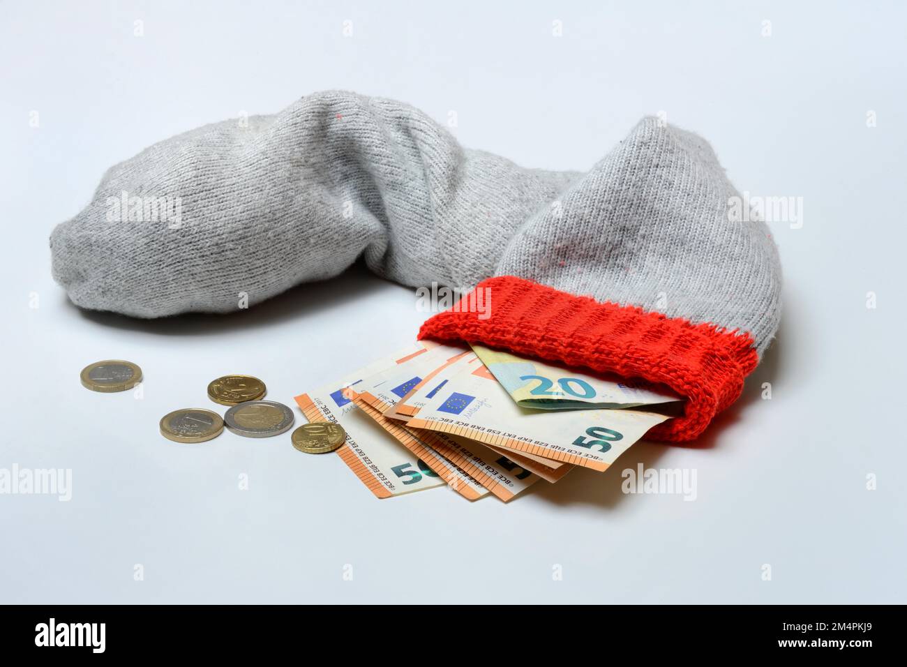 Banknotes in woollen sock, savings stocking, euro notes and coins Stock ...