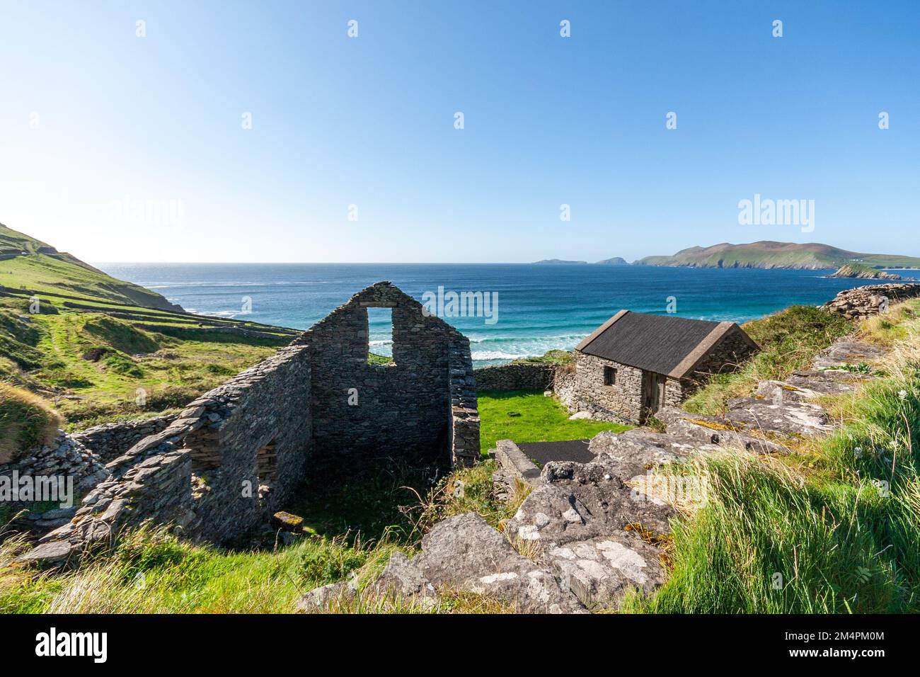 The historical ruins on the Dingle Peninsula under a blue sky in County ...