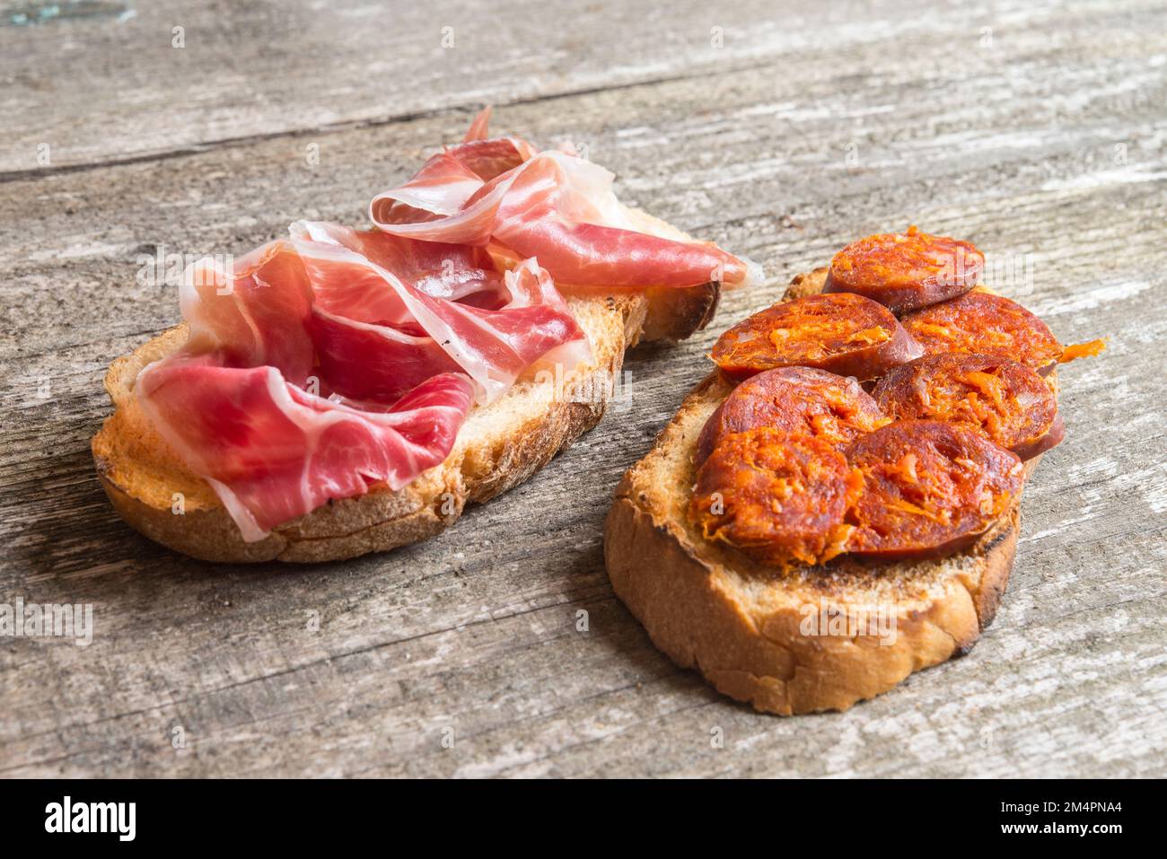 bread toast with chorizo and ham (spanish tapa Stock Photo - Alamy