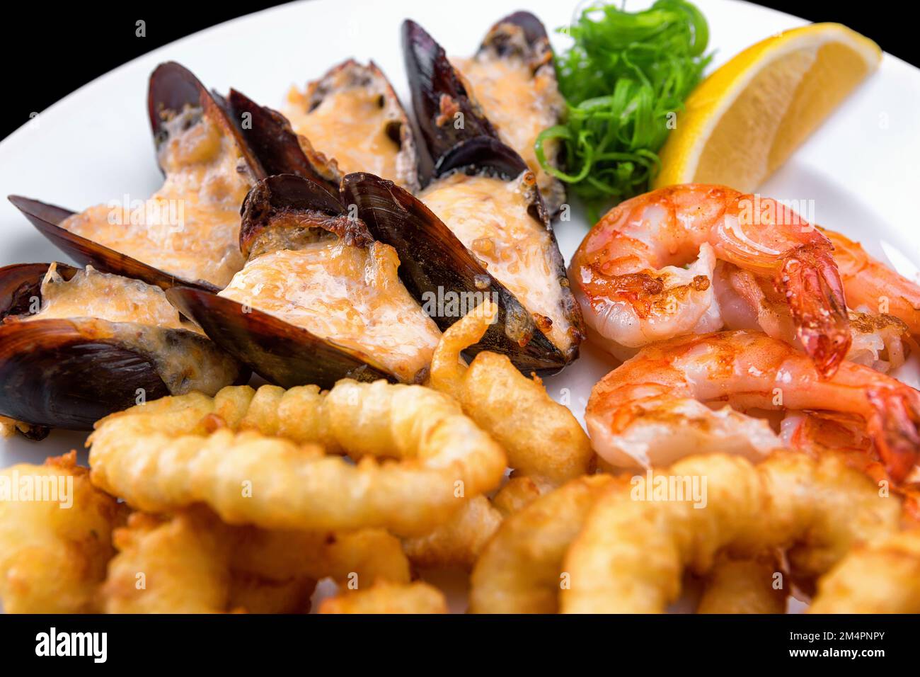 Seafood, mussels, shrimp and squid in batter, with lemon, close-up ...
