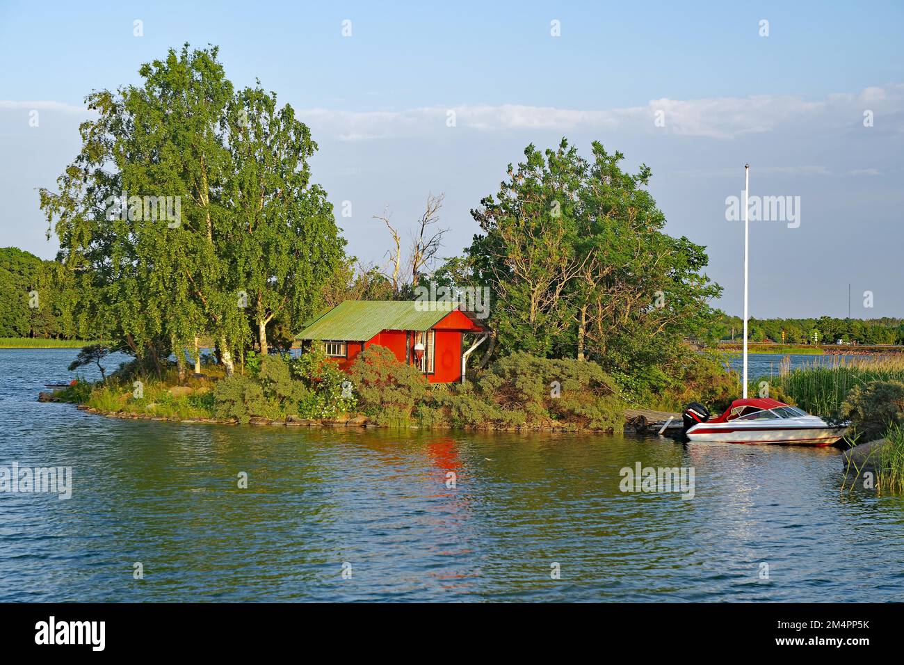 Small red cottage with boat on an island, evening mood, autonomous ...