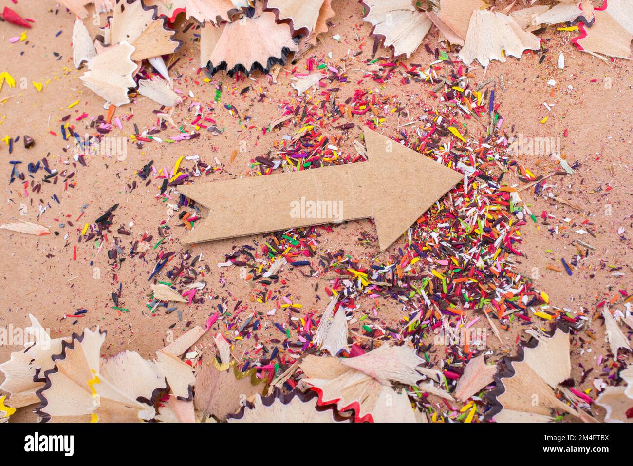 Arrow cut out of paper amid pencil shavings on canvas Stock Photo - Alamy