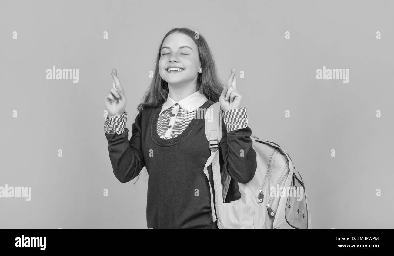 happy child with school backpack cross fingers making wish on yellow ...