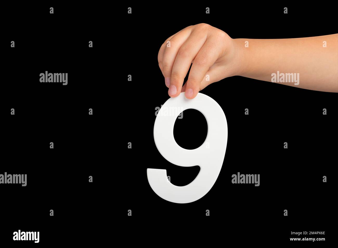 Number nine in hand isolated on black background. Number 9 in a child's ...