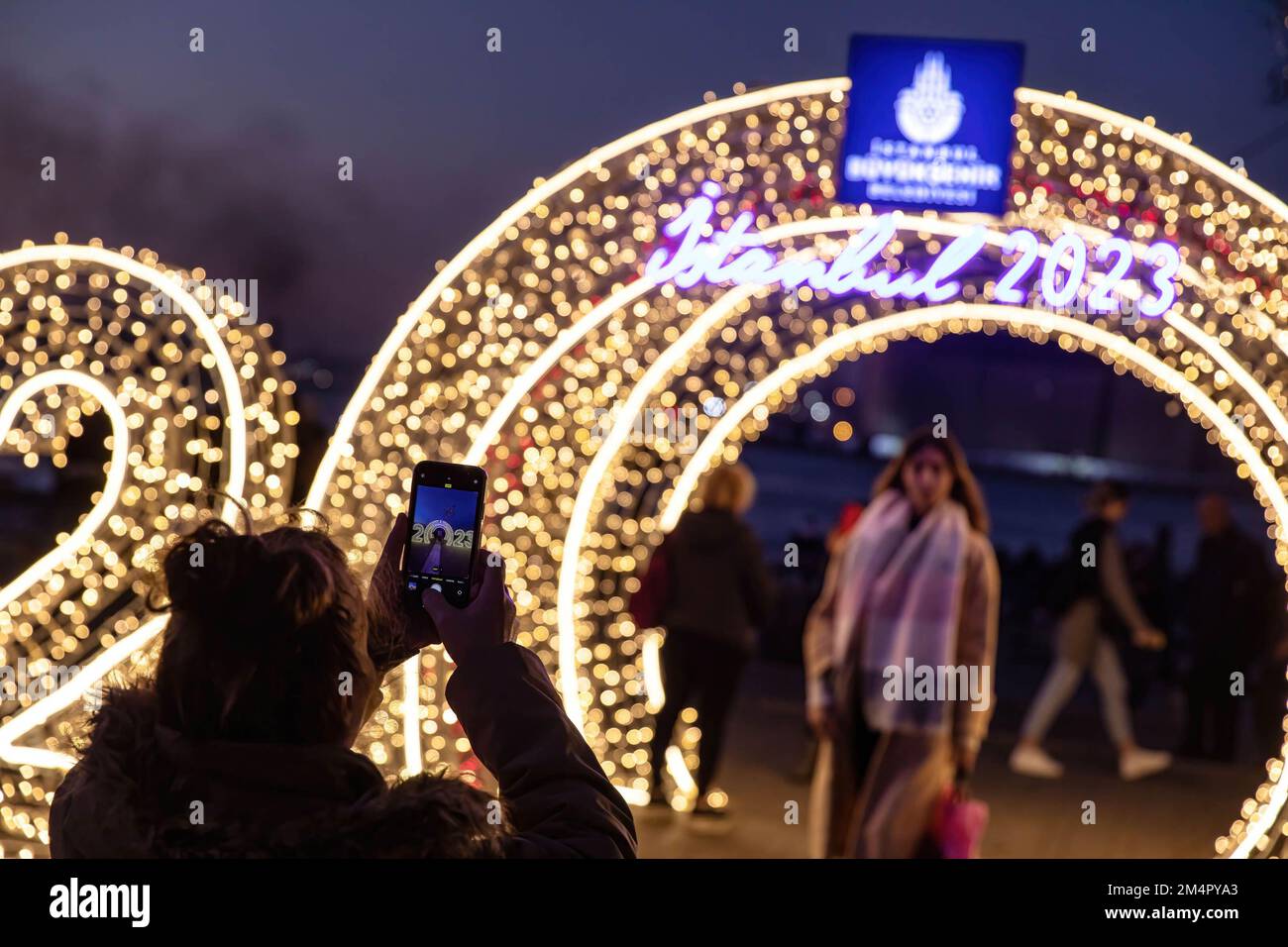 People take photos with their mobile phones in front of the 2023 themed ...