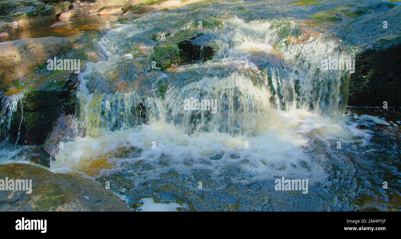 Close-up of mountain fast river waterfall on a sunny summer day. Nature ...