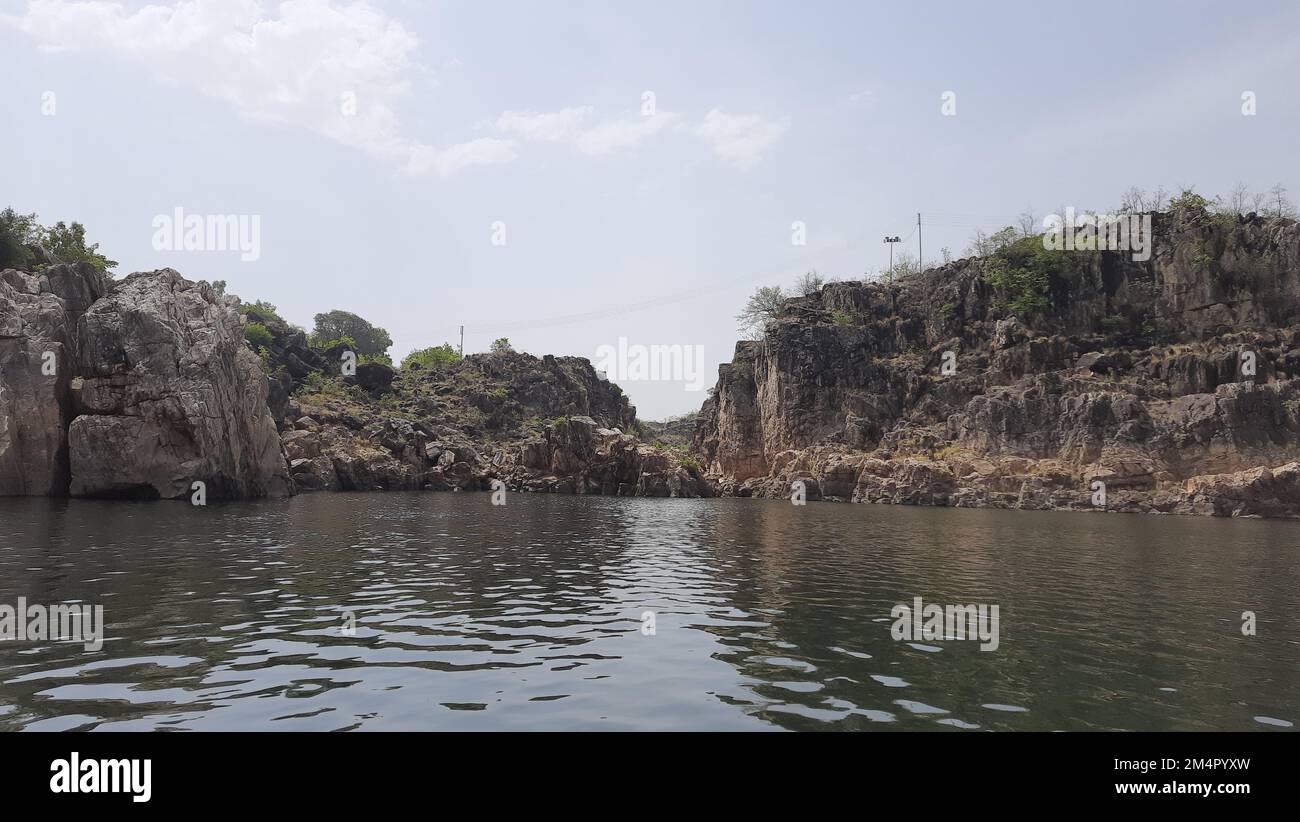 A beautiful nature scene with the cliffs and lake under a blue sky ...
