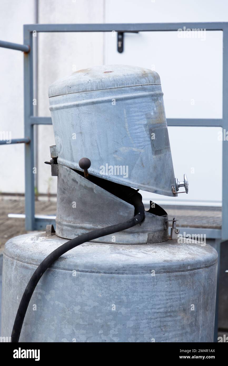 A small round metal container is mounted on a larger one. The smaller ...