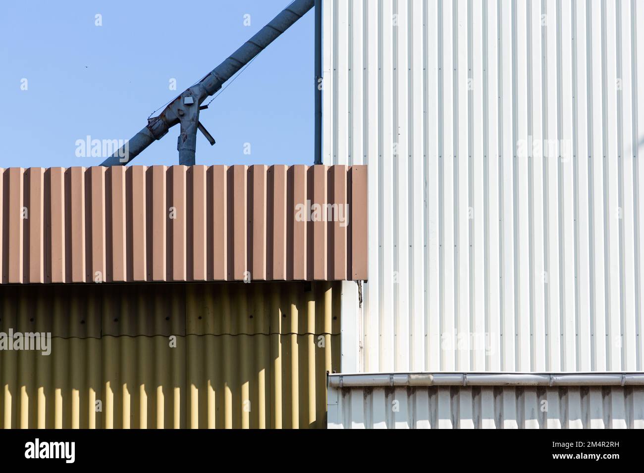 The metal facades of an industrial building in white, brown and green ...