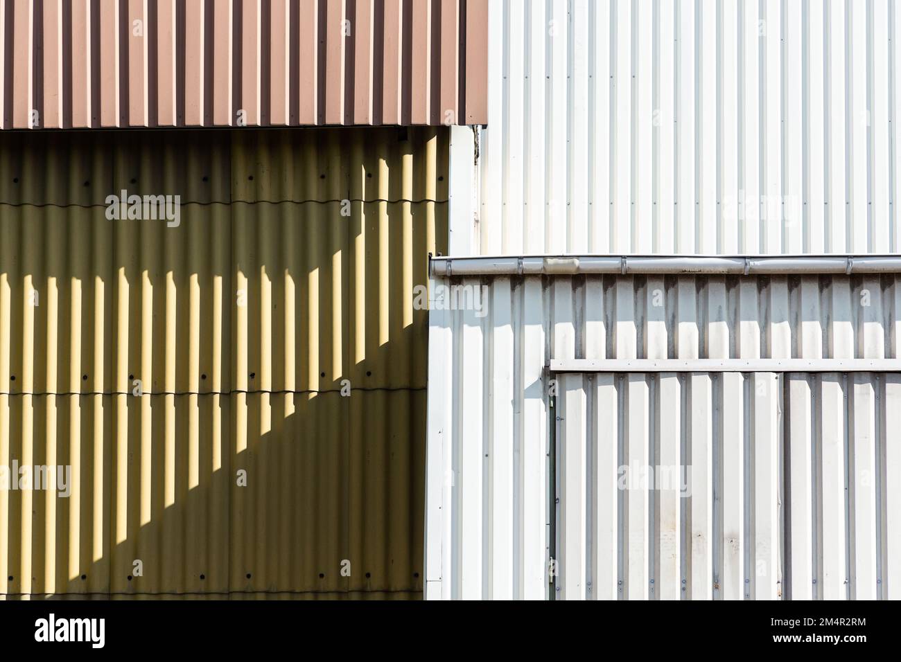 The metal facades of an industrial building in white, brown and green ...