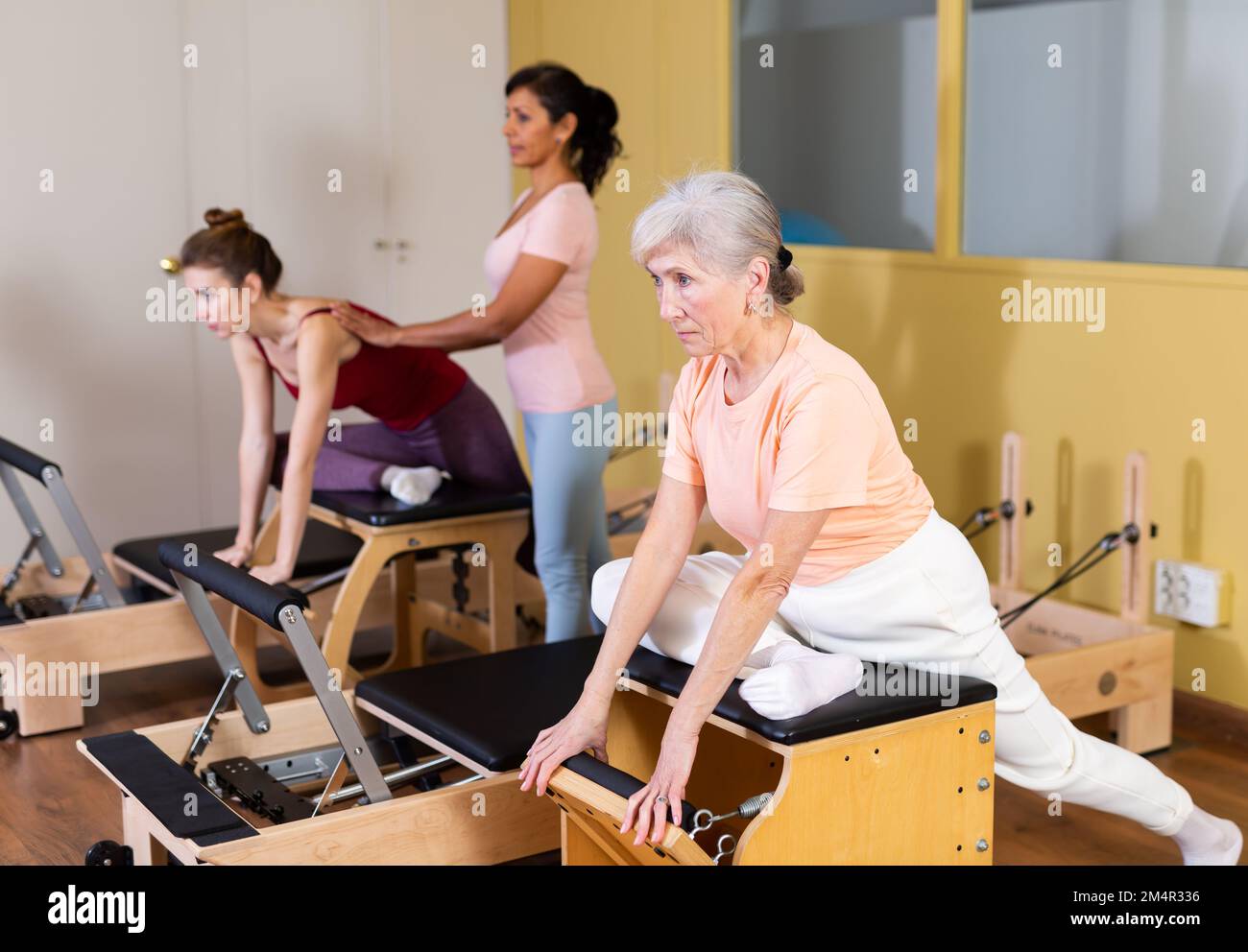 Elderly woman doing exercises on wunda chair in pilates studio Stock ...