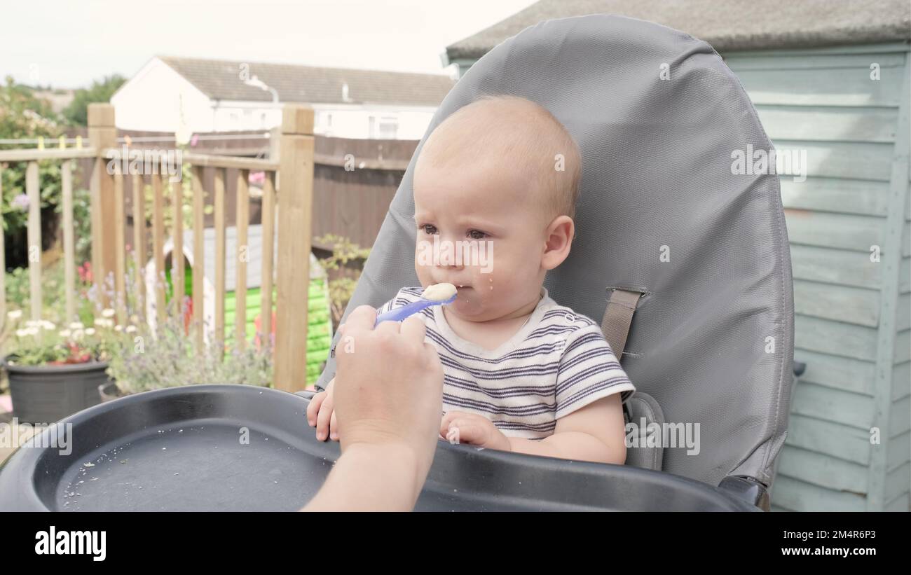 Woman feeding Tired child with spoon. Mom feed crying Sad baby Boy with ...