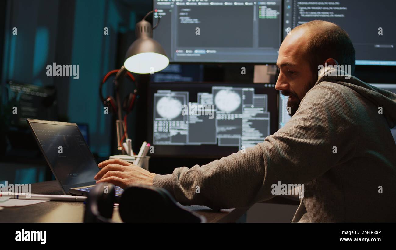 Database admin answering landline phone call late at night, talking on office telephone with ...