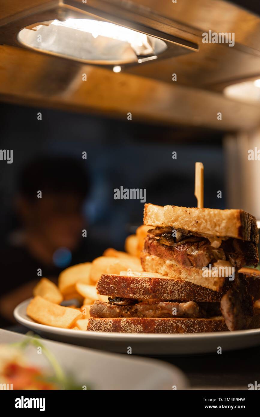 A steak sandwich sitting under a heat lamp waiting to be served Stock ...