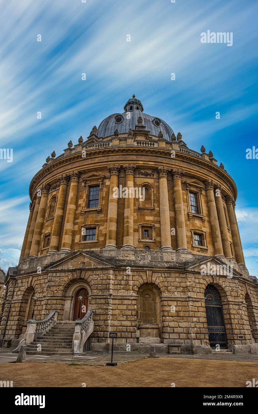A vertical shot of Radcliffe Camera library on blue cloudy sky ...
