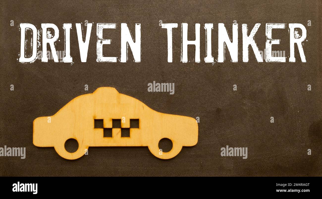 Closeup on businessman holding a card with text DRIVEN THINKER ...