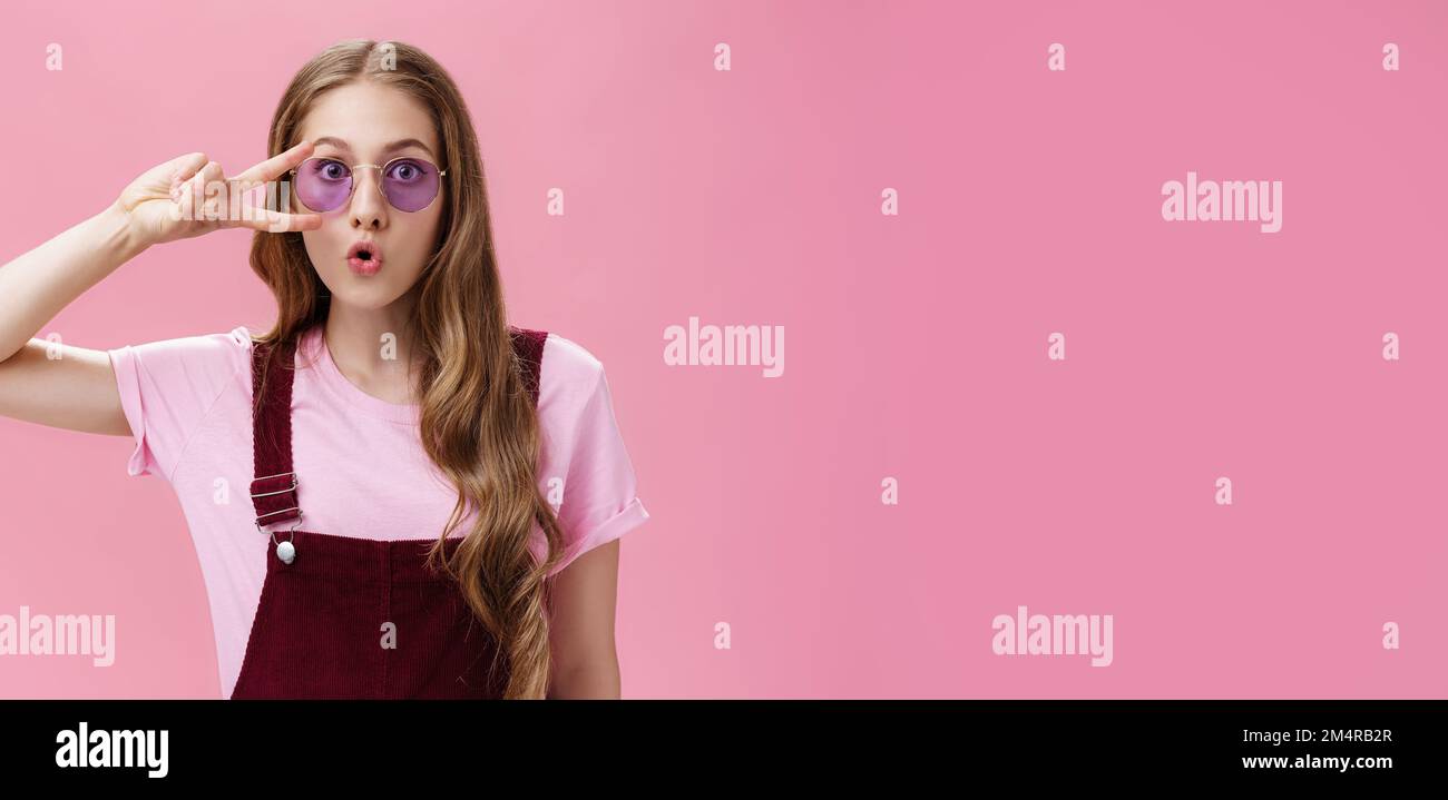 Portrait of stylish energetic girl with scar on hand showing peace sign ...