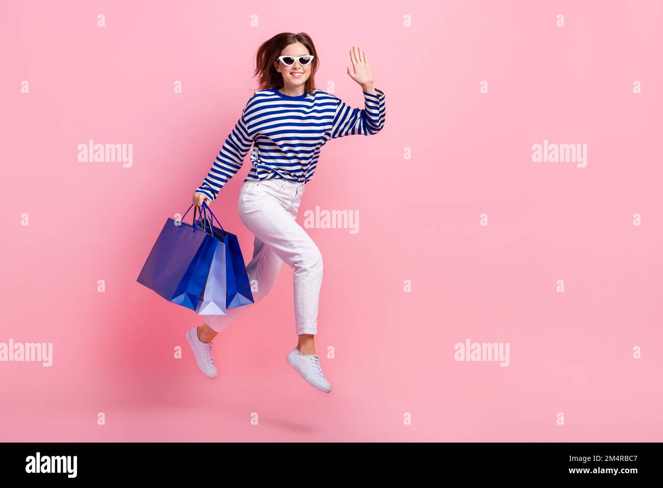 Full length photo of cheerful attractive person rush jumping hold bags ...