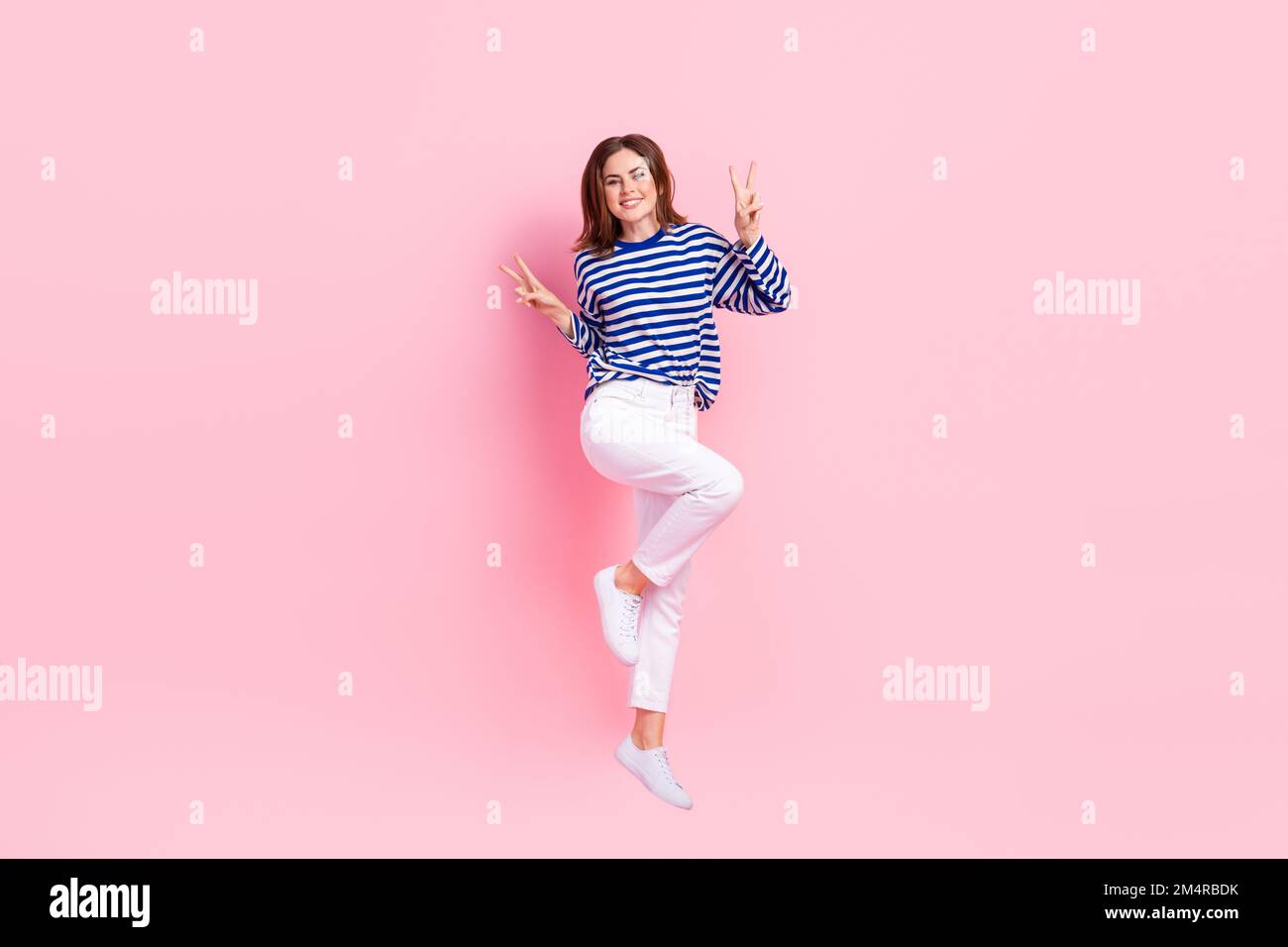 Full size photo of charming overjoyed girl jumping hands fingers show v ...