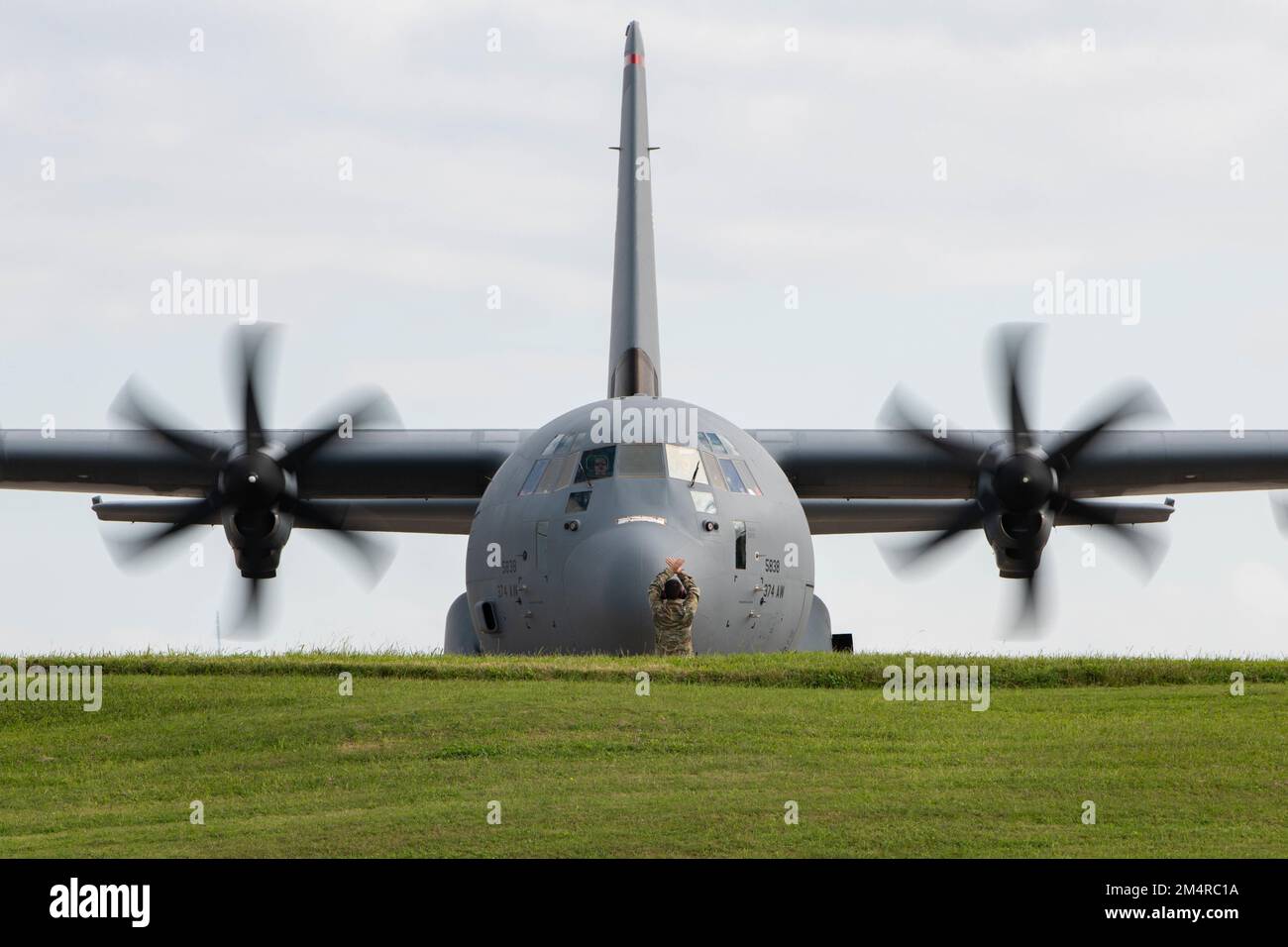 An Airman from the 733rd Air Mobility Squadron signals a U.S. Air Force ...