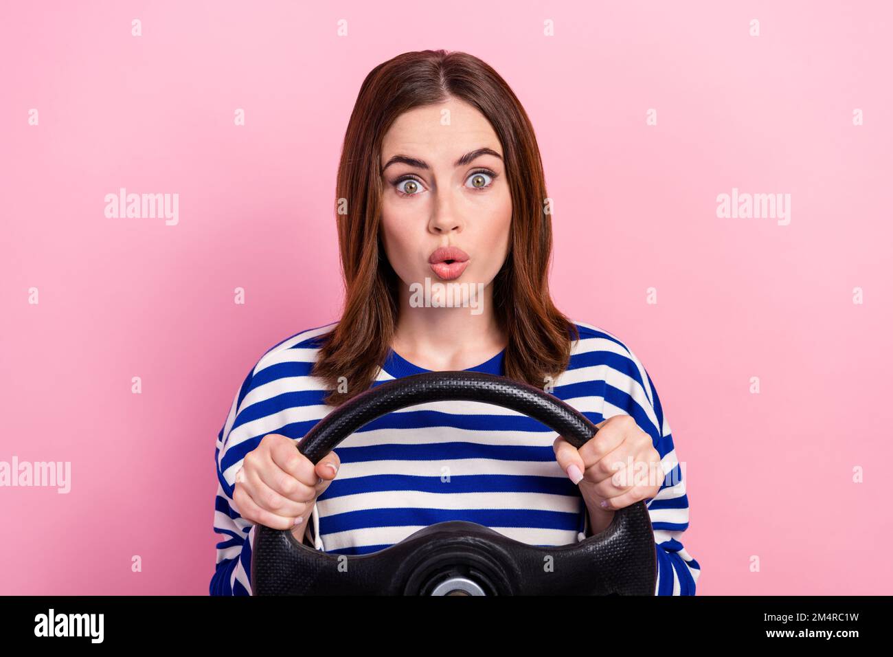 Photo of impressed girl pouted lips staring unexpected hands hold wheel ...