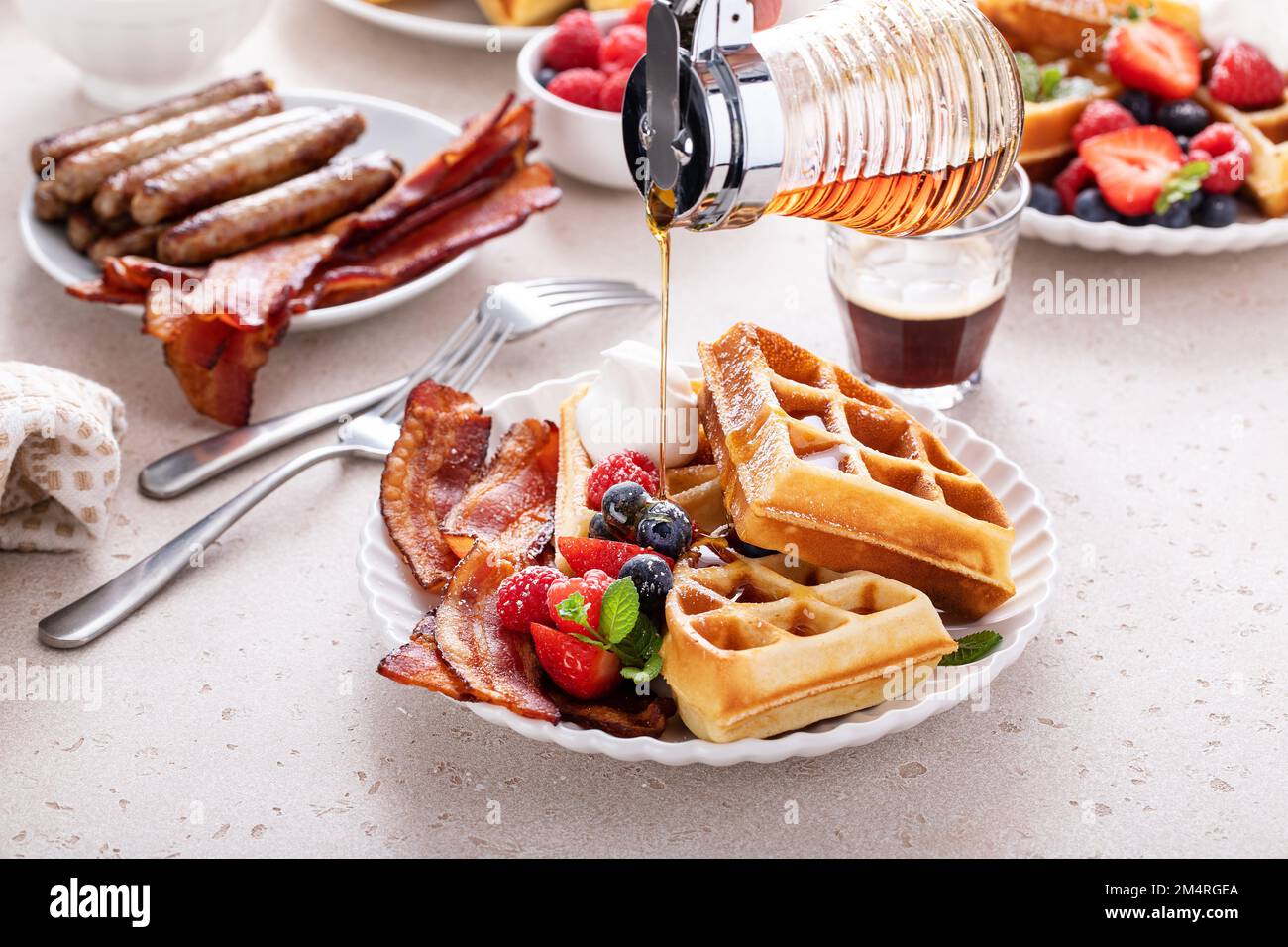 Breakfast table with waffles, croissants and bacon Stock Photo - Alamy