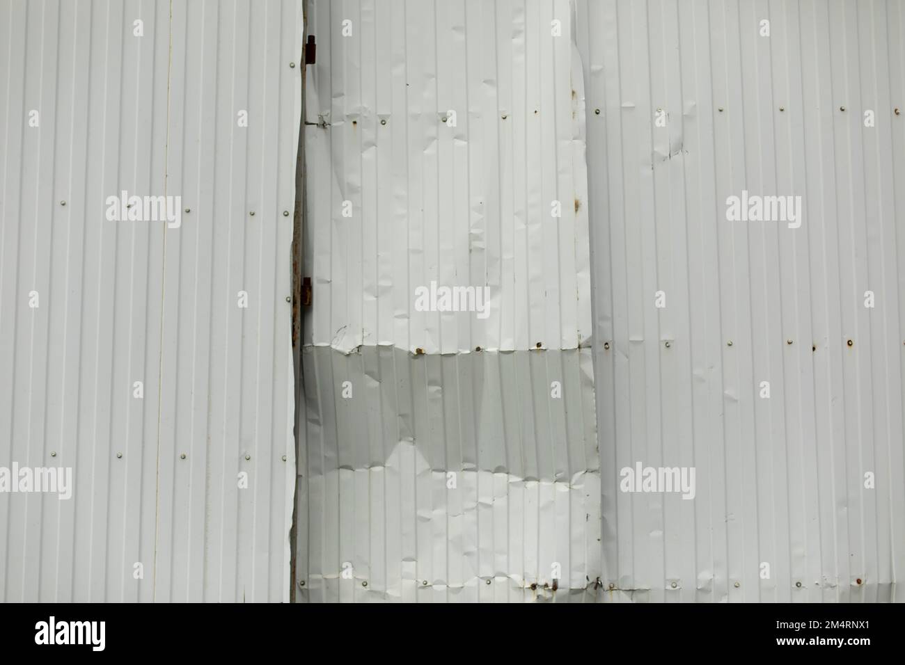 Broken steel profile fence. Wrinkled metal fence. White steel barrier ...