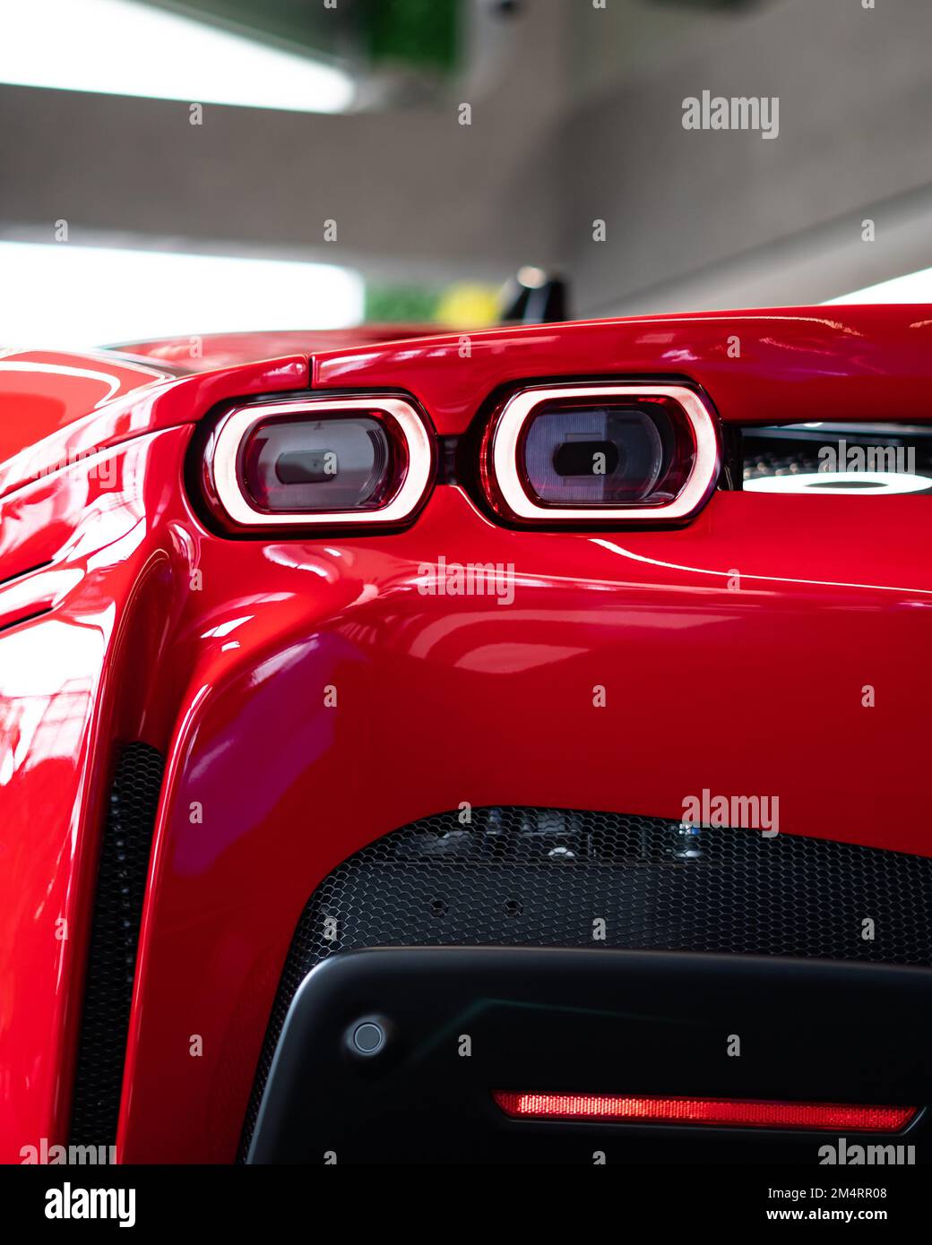 A vertical closeup shot of the red Ferrari SF-90 left taillight, with ...