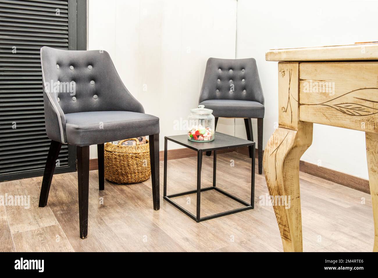 Waiting room with two gray fabric stools with buttons and a small table ...