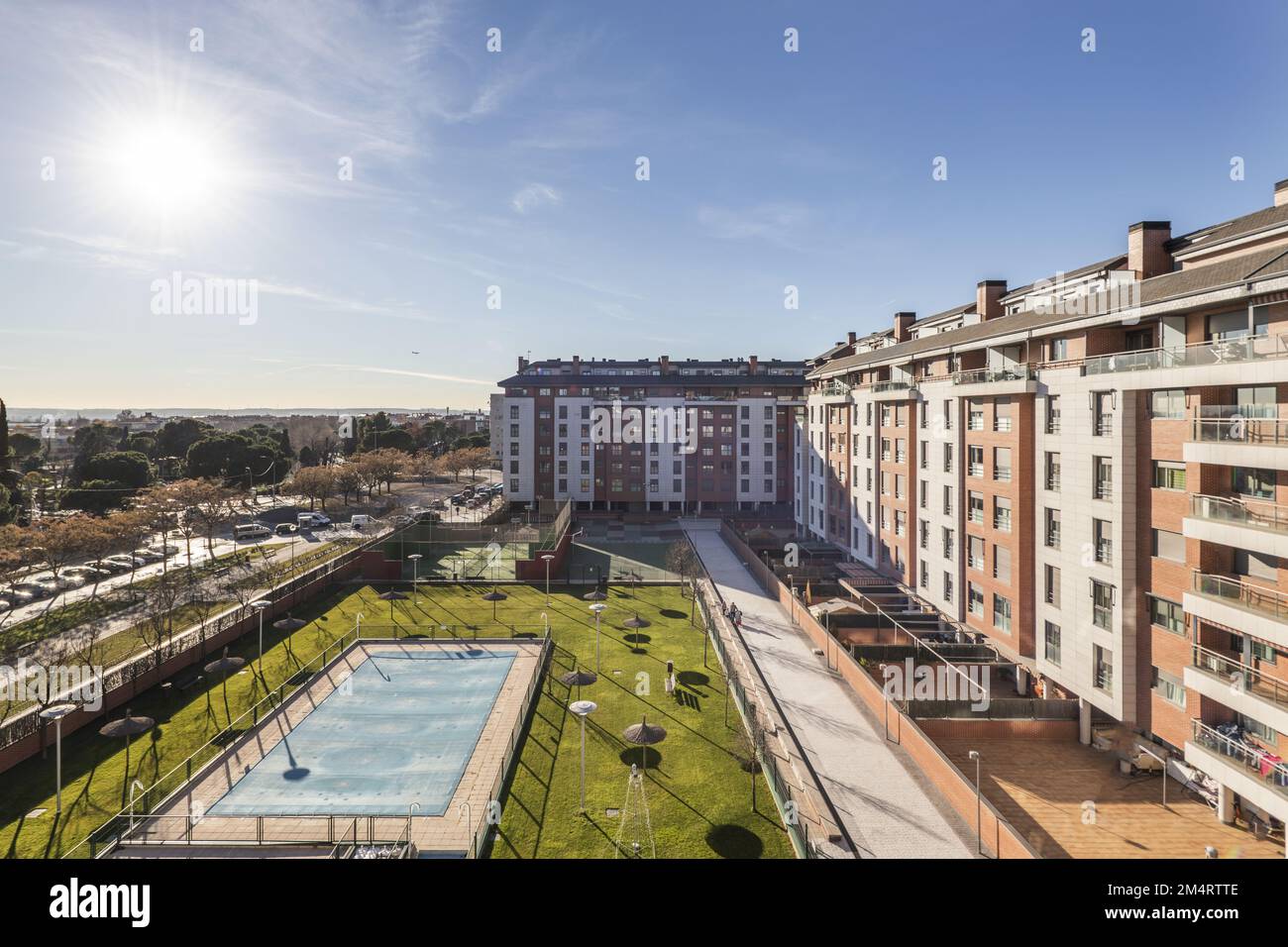 Common areas of an urbanization with swimming pools, benches and flower ...