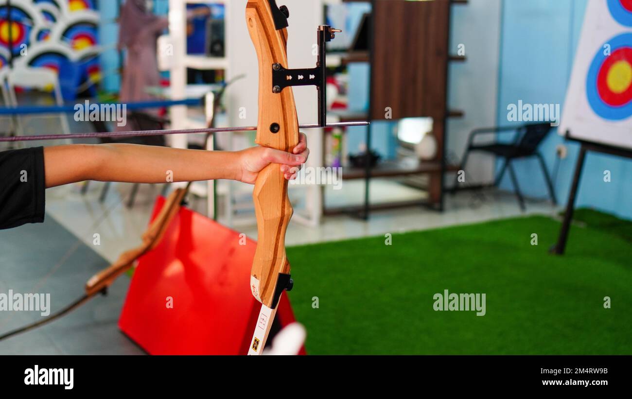 Close up of child's hands practicing archery. Archery target ring. Archery. Practice with a bow ...