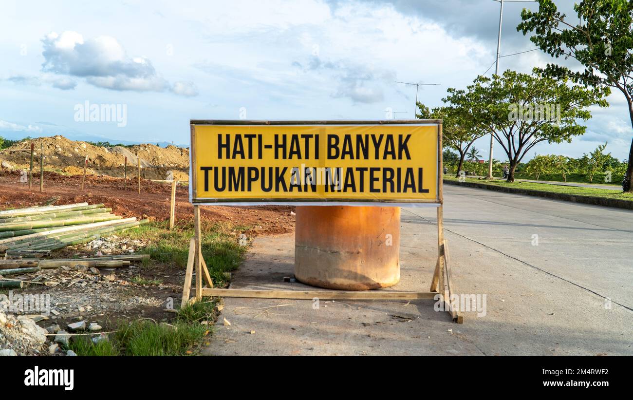 "Hati - hati banyak tumpukan material" warning signs posted in the road ...