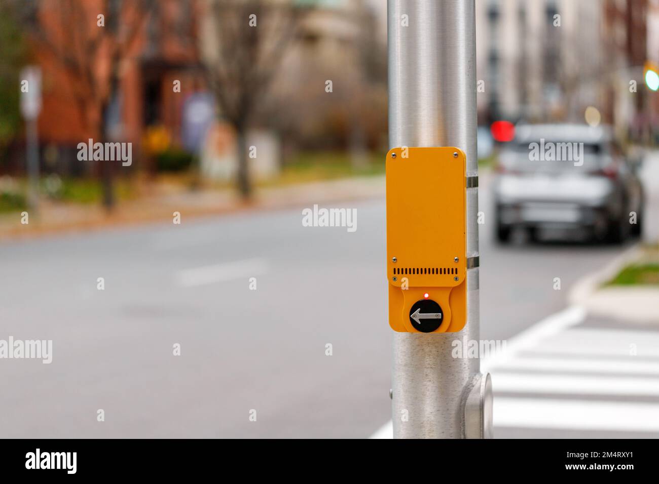 Yellow pedestrian sign at a traffic light at an intersection in street ...