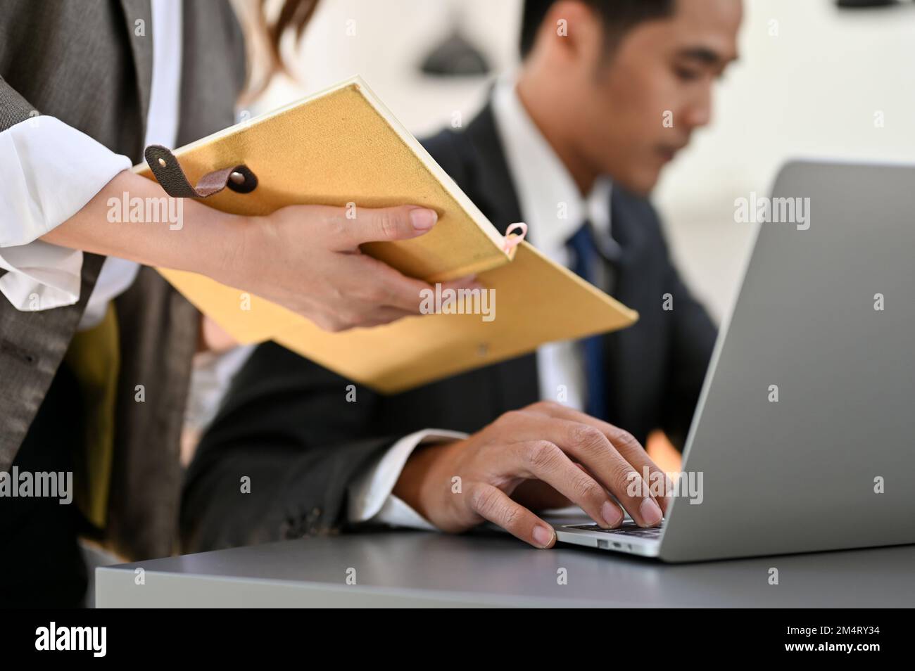 Attractive young Asian female secretary or assistant noting something ...