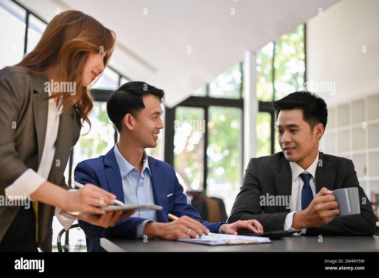 Professional and smart Asian male CEO in formal business suit sipping ...