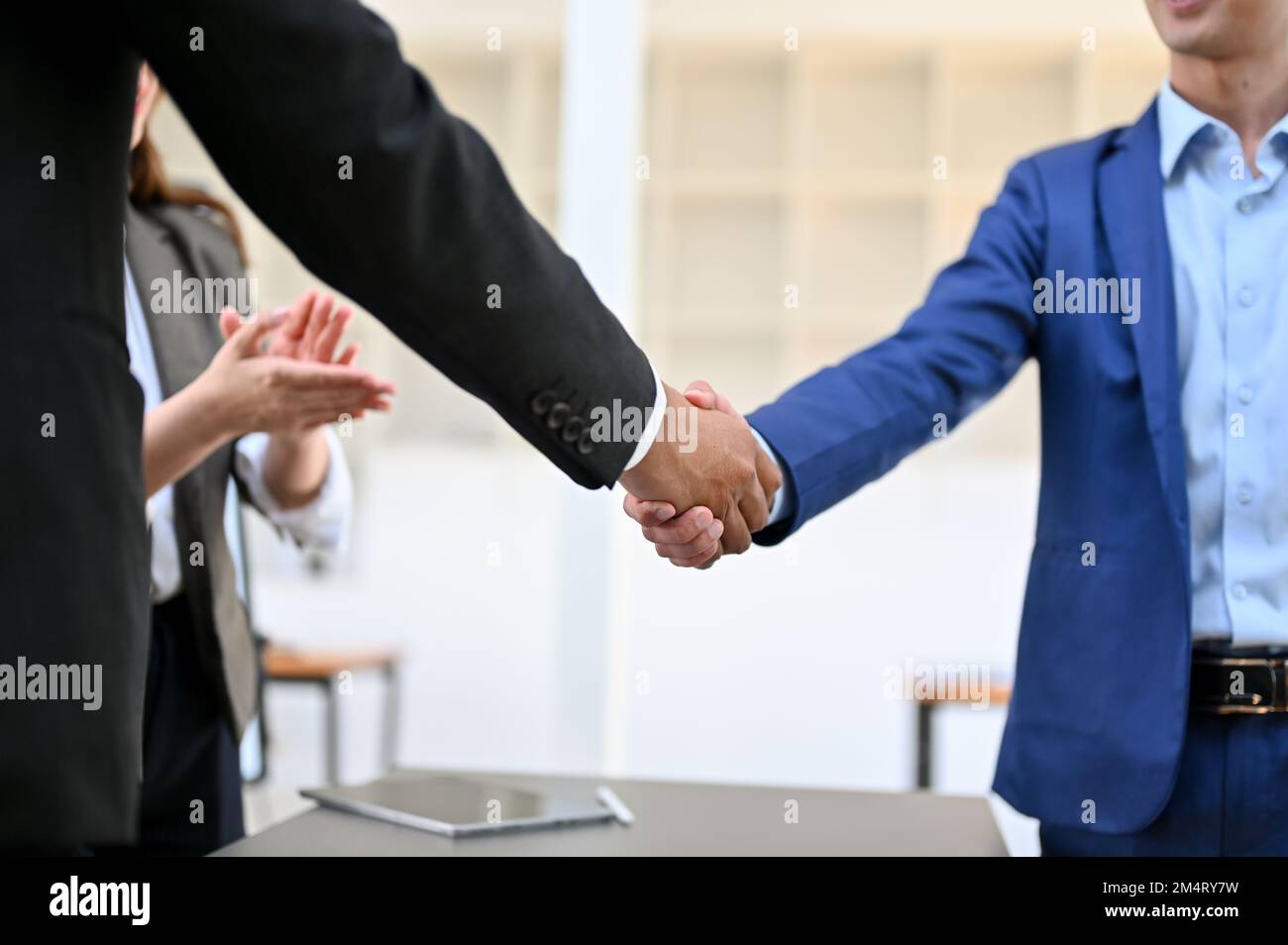 Two successful businessmen shaking hands after a corporate meeting ...