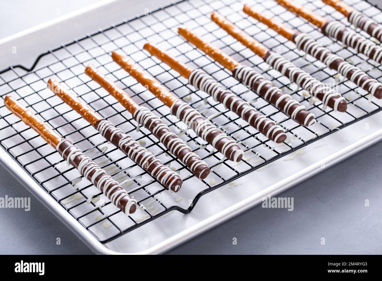 Chocolate covered pretzel rods freshly made on a cooling rack with dark ...