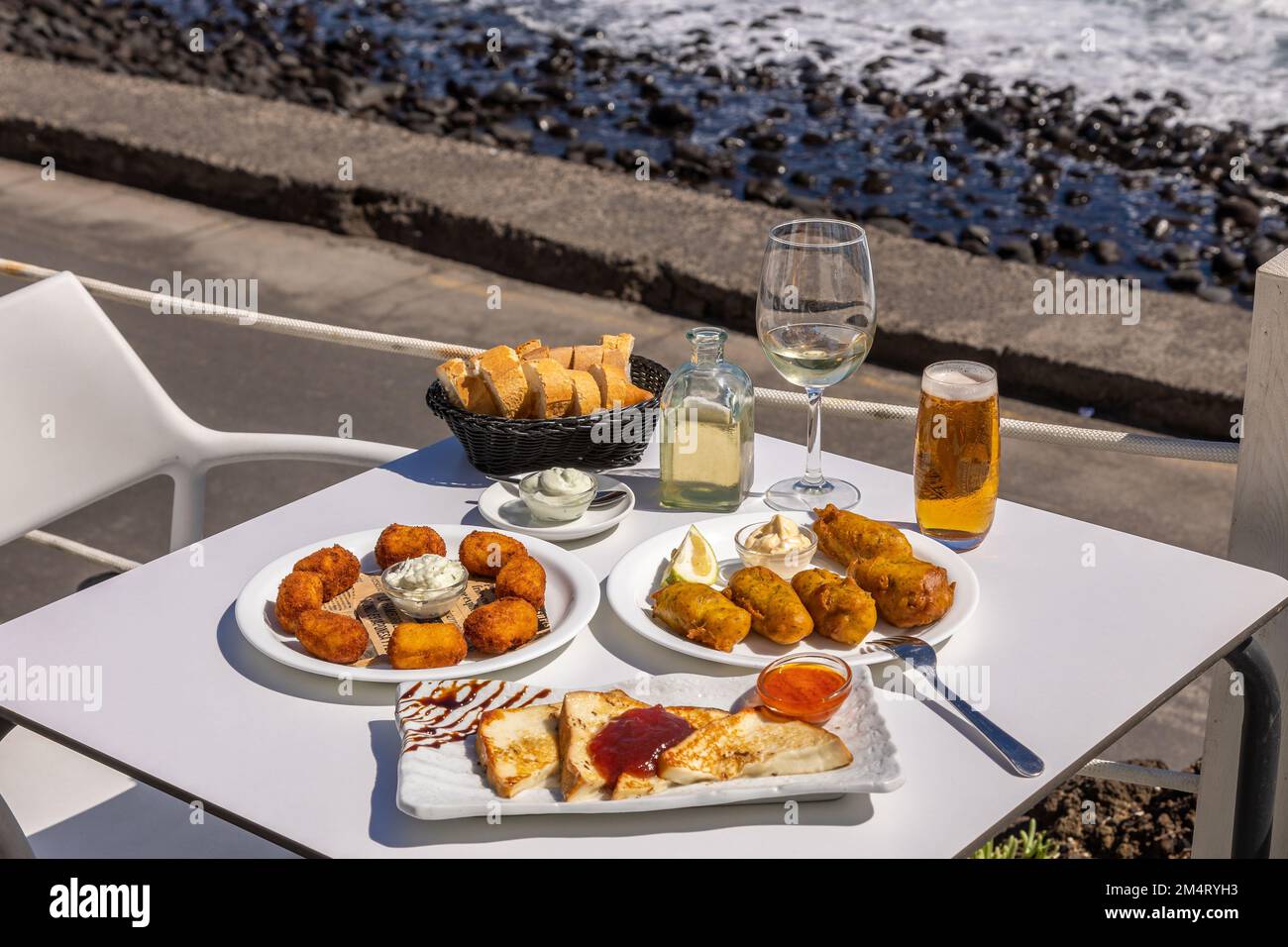 A close-up shot of fried fast food and French toast on a white table ...