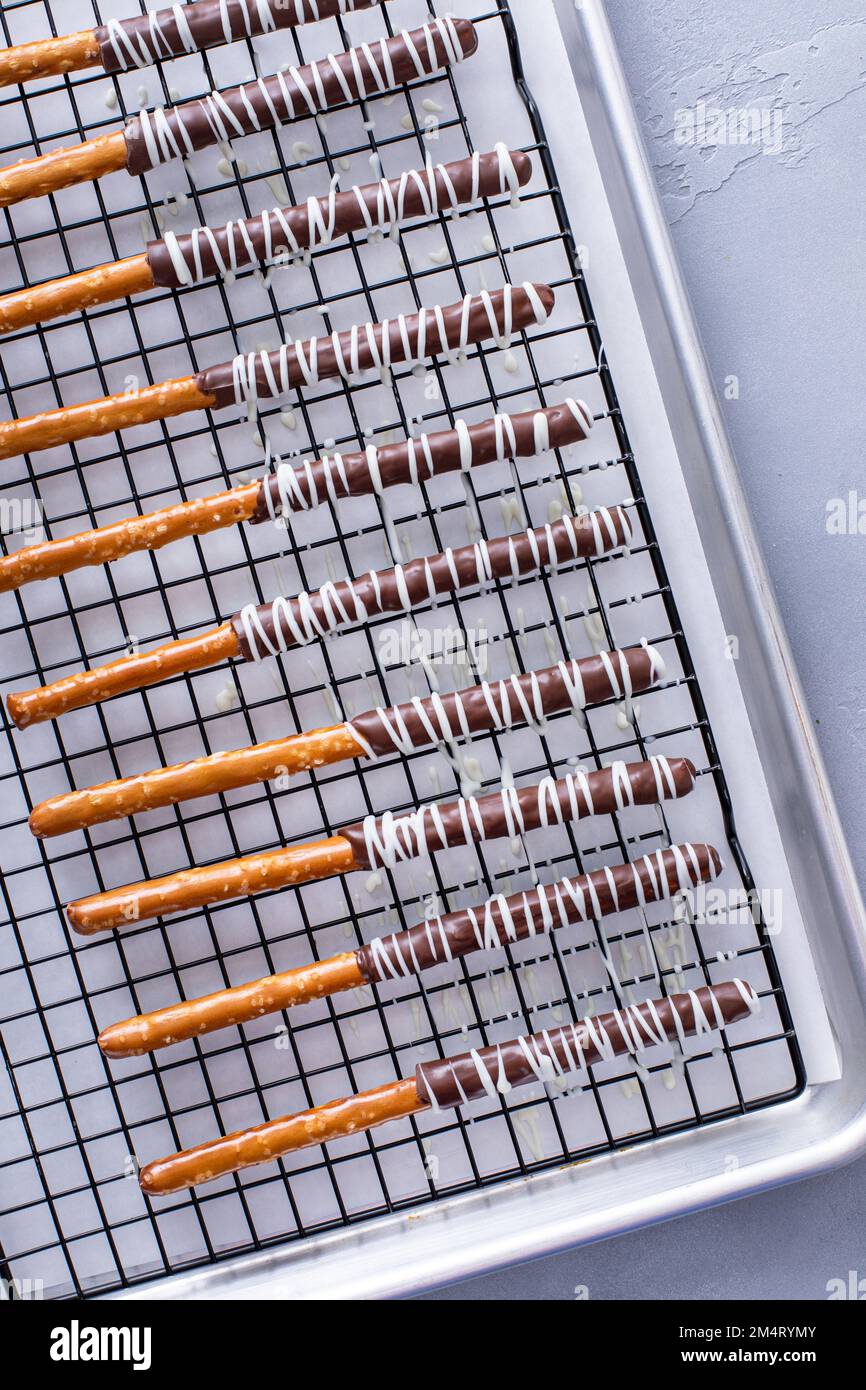 Chocolate covered pretzel rods freshly made on a cooling rack with dark ...