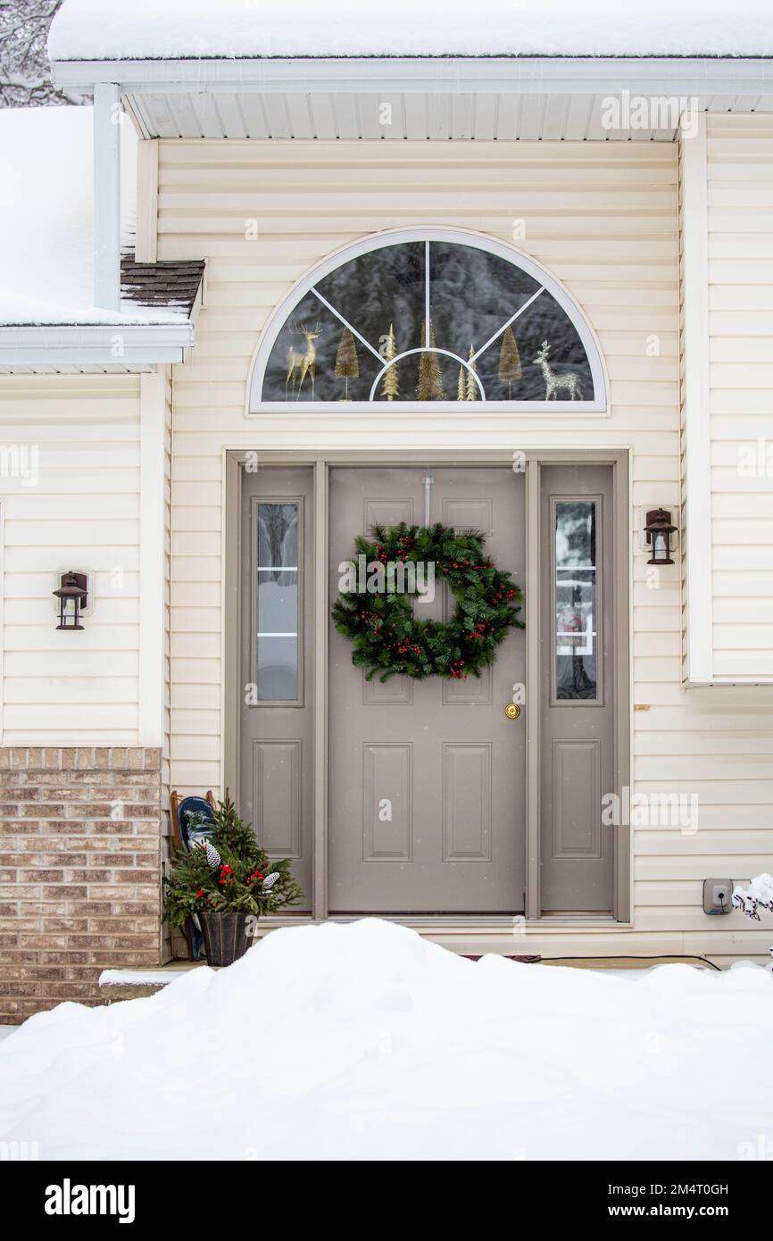 Front door with Christmas wreath and snow, vertical Stock Photo - Alamy