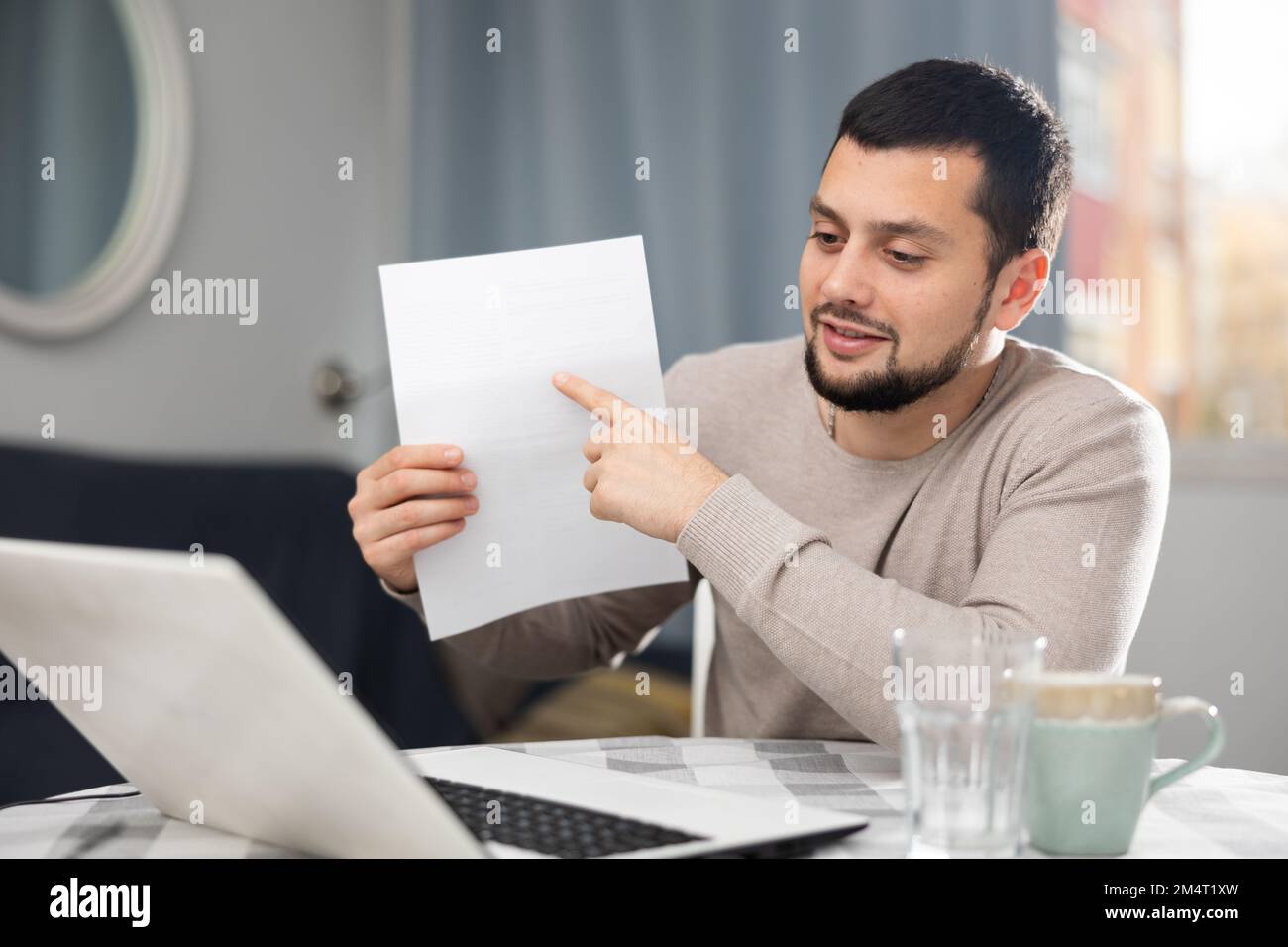Smiling man chatting online using laptop Stock Photo - Alamy