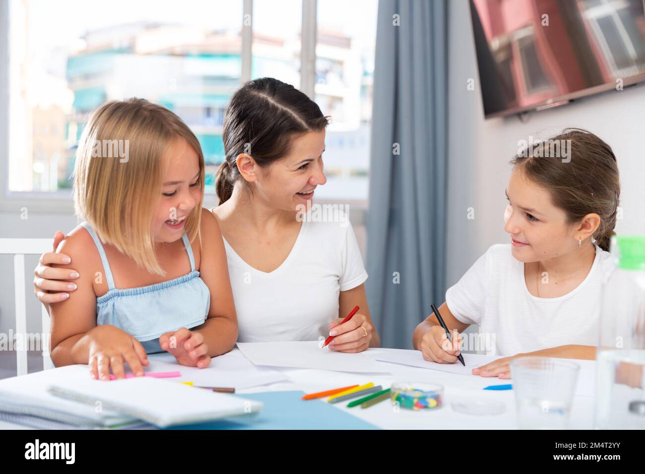 Young woman and two daughters drawing together Stock Photo - Alamy