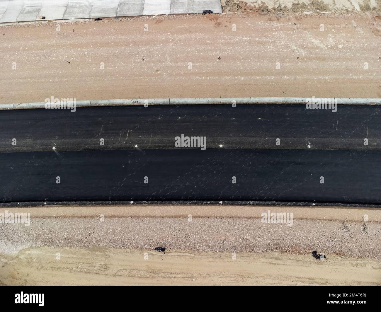 Mountain road constraction. Workers reinforce the slope over the new ...