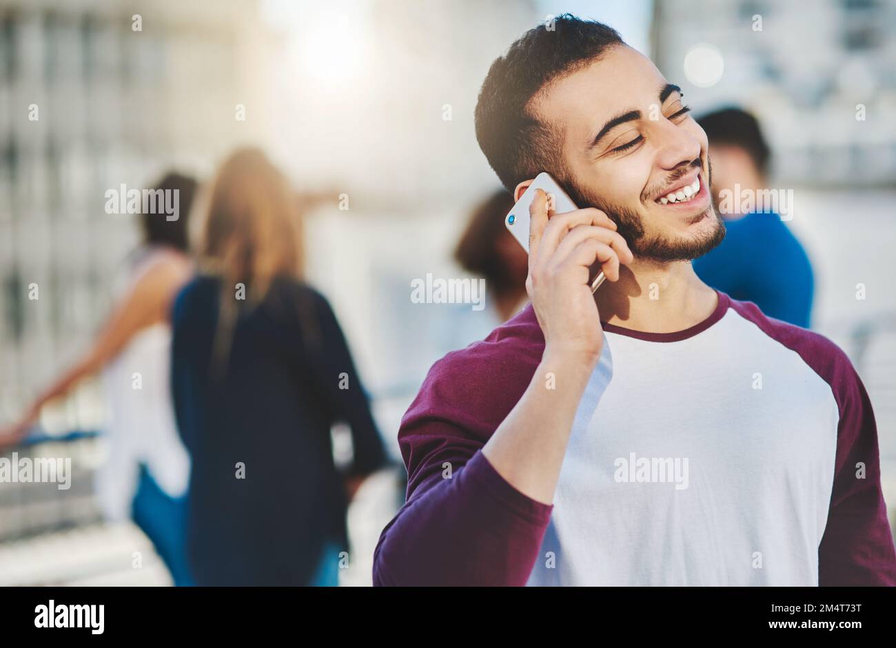 Wanna hang. a handsome young man making a phone call while standing ...